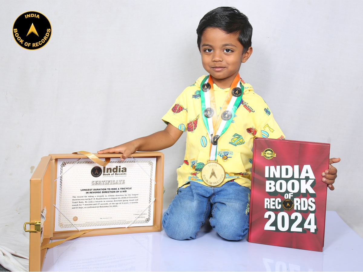Longest duration to ride a tricycle in reverse direction by a kid